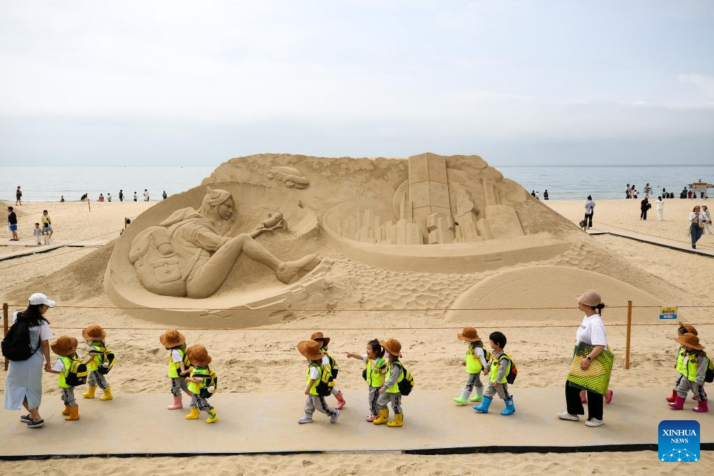 Tourists view sand sculptures at Haeundae Beach in Busan, S. Korea-Xinhua