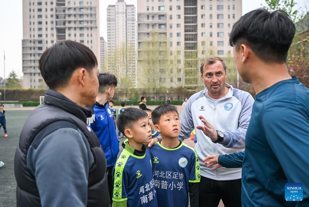Foreign football coaches give instructions to young football players in ...