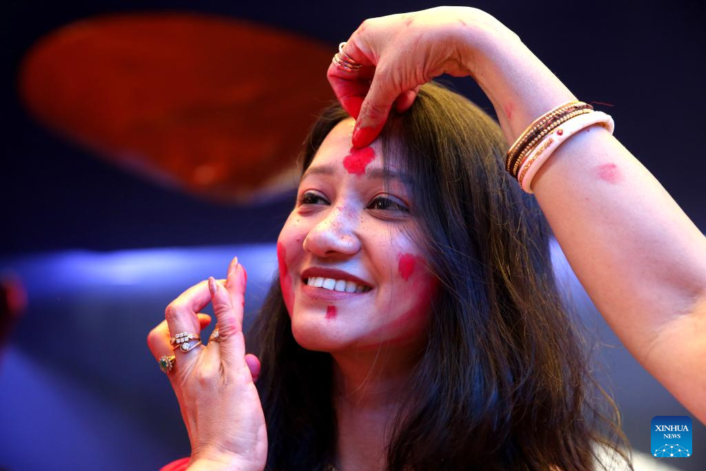 Women apply vermillion on each other's faces during Hindu festival of Navratri-Xinhua