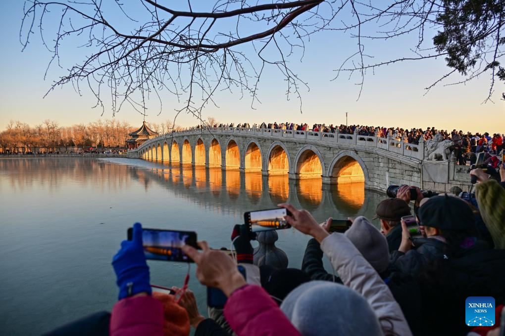 People visit 17-Arch Bridge in Summer Palace, China's Beijing-Xinhua