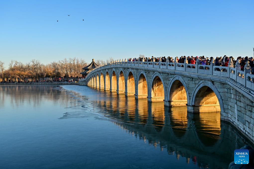 People visit 17-Arch Bridge in Summer Palace, China's Beijing-Xinhua