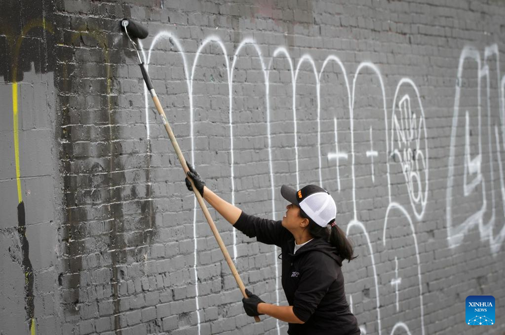 Volunteers cover up graffiti on walls in Chinatown of Vancouver-Xinhua